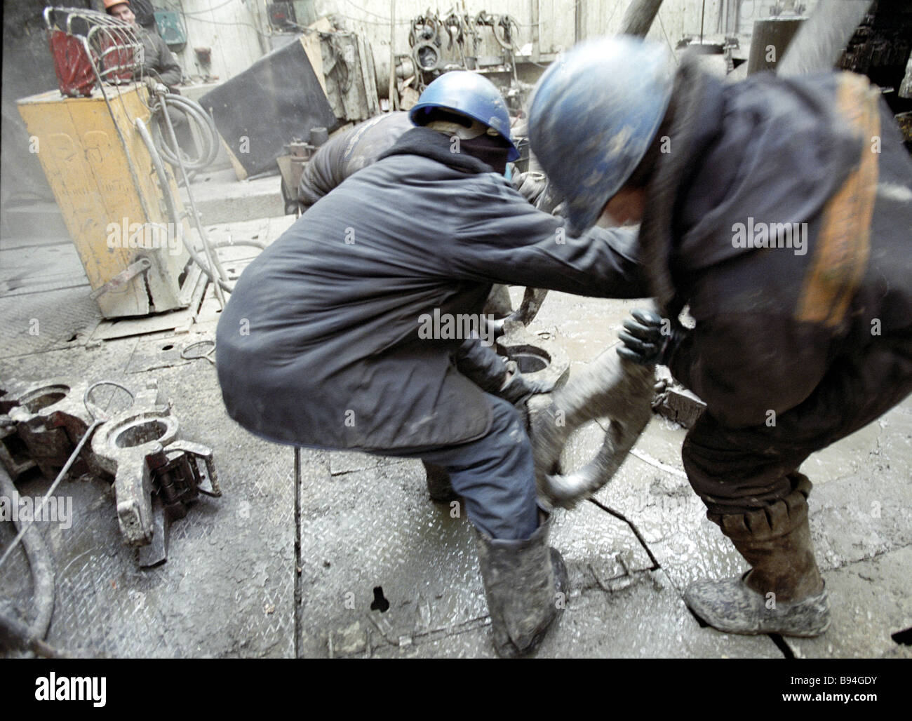 Oilmen working at the drilling rig Stock Photo - Alamy