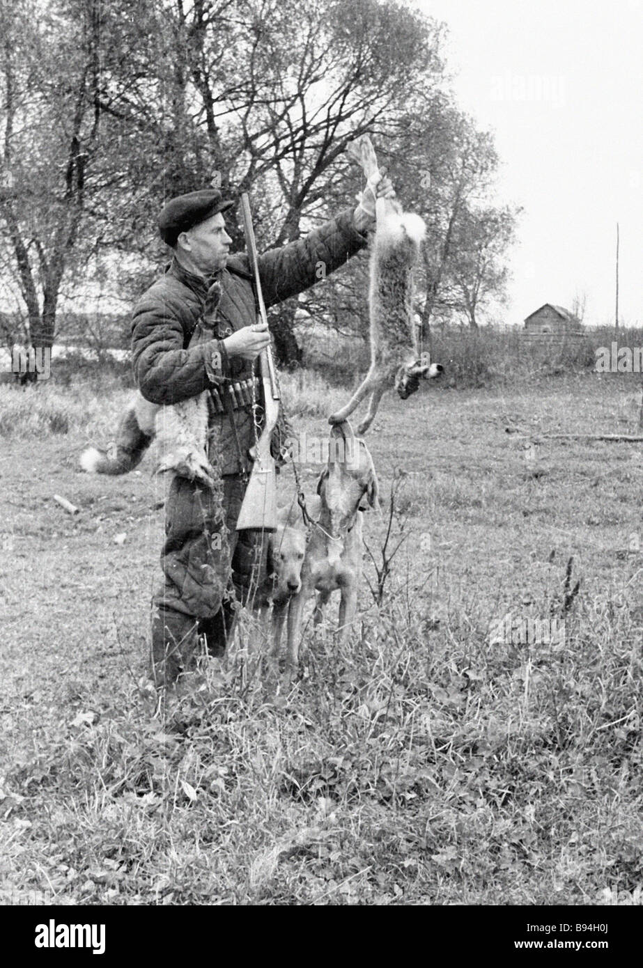 Hunter with his trophies a hare and a fox Stock Photo - Alamy