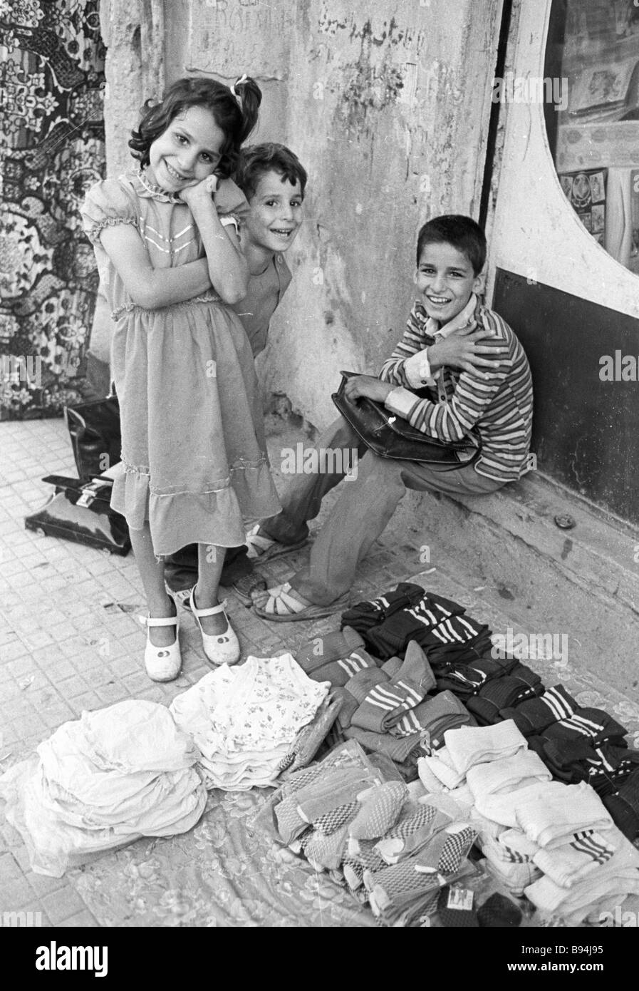 Children selling knitted goods in a Khoms street Stock Photo - Alamy
