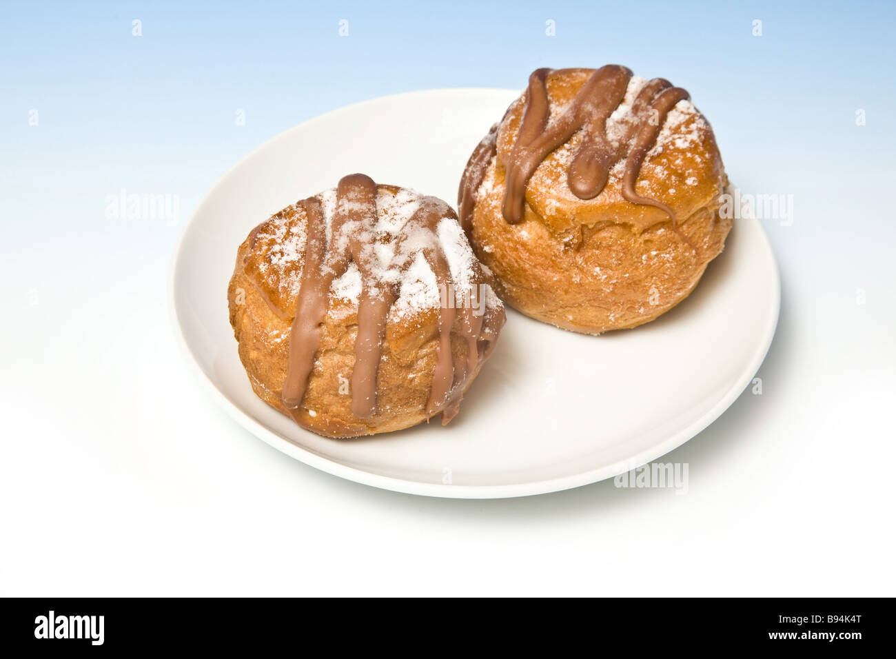 Cream buns on a graduated blue studio background Stock Photo - Alamy