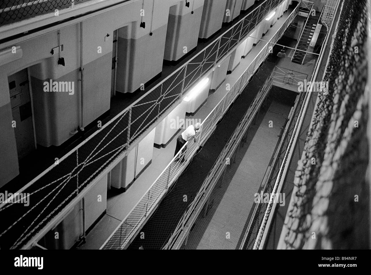 Prison Officer leans over the railings at one of the landings in ...
