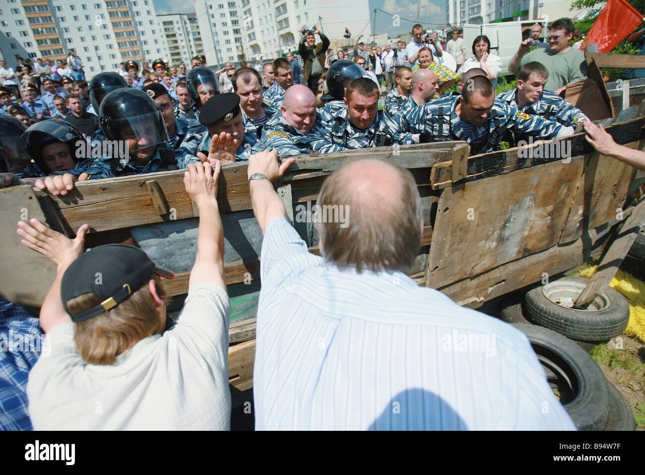 Indignant people next door oppose riot police as a family is violently ...