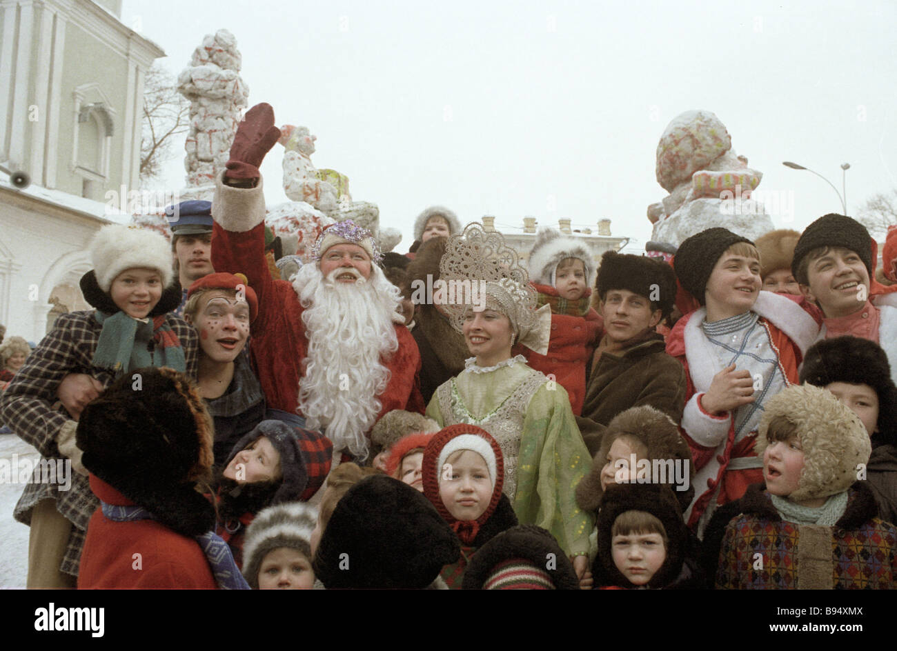Father Frost and Snow White surrounded by children during festival ...