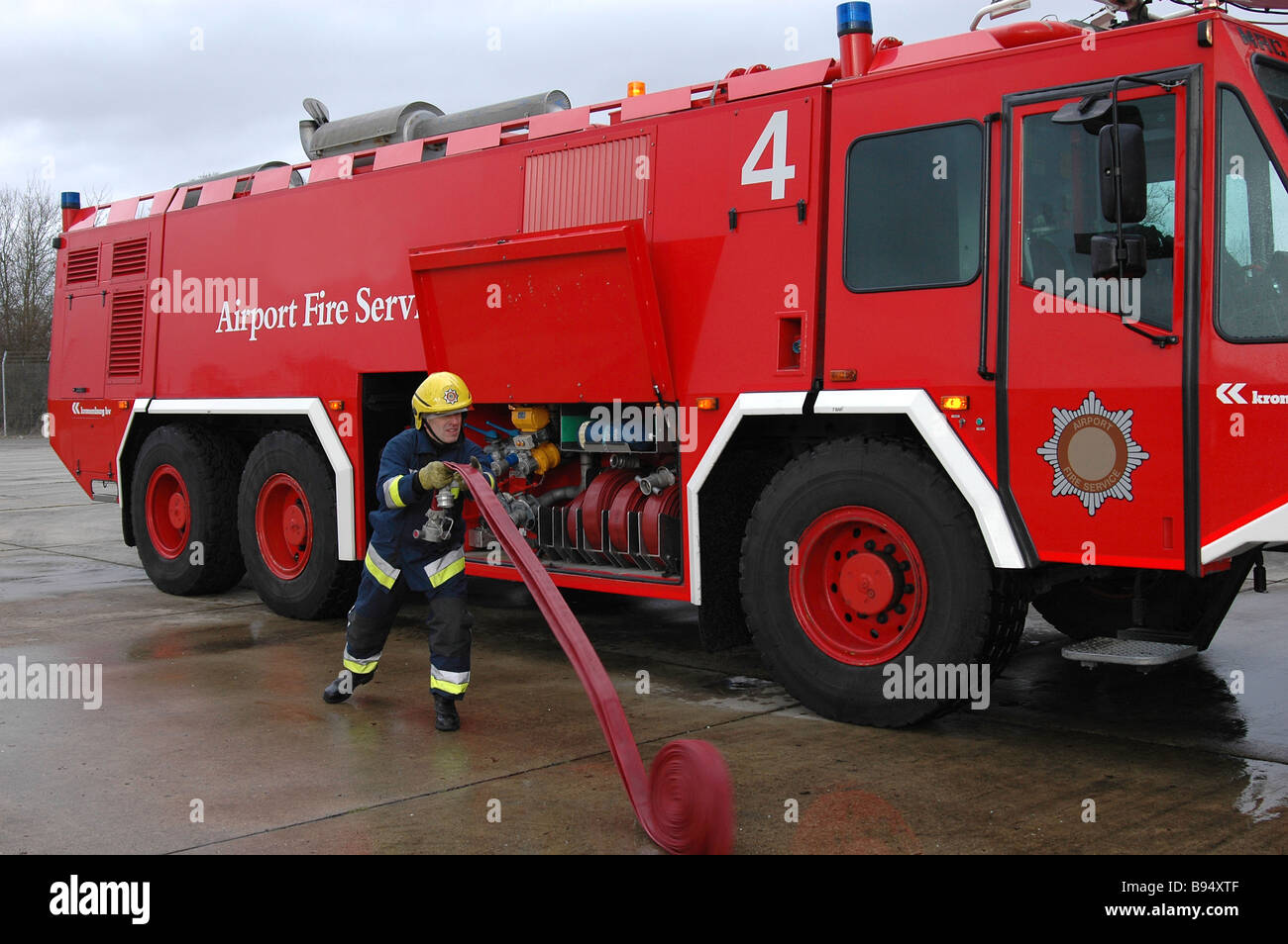 A firefighter bowling out a hose in front of his fire appliance Stock ...