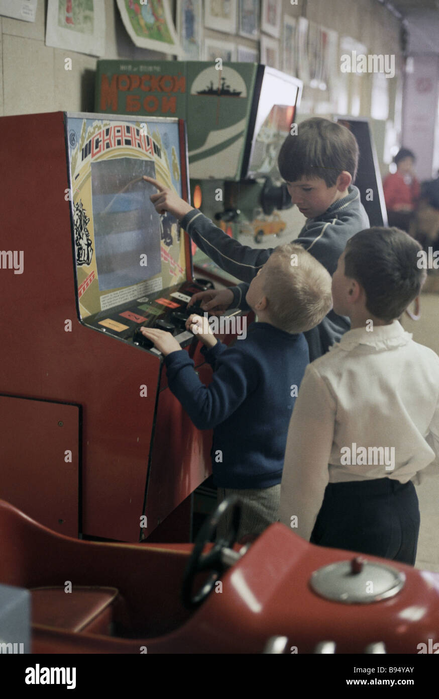 Children crowding around a game machine in the Saturn cinema Stock ...