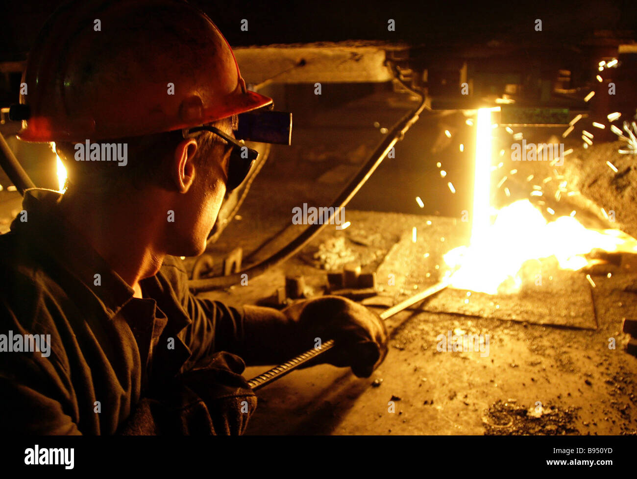 A steel founder cleaning molding equipment for melted steel of ...