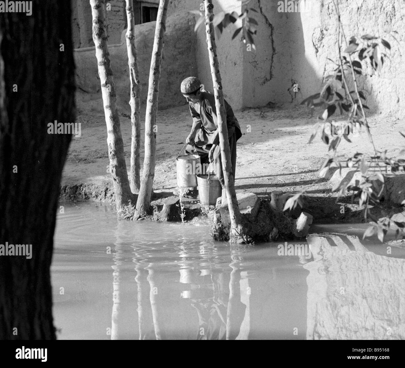 An Afghan villager takes water from a pond Stock Photo - Alamy