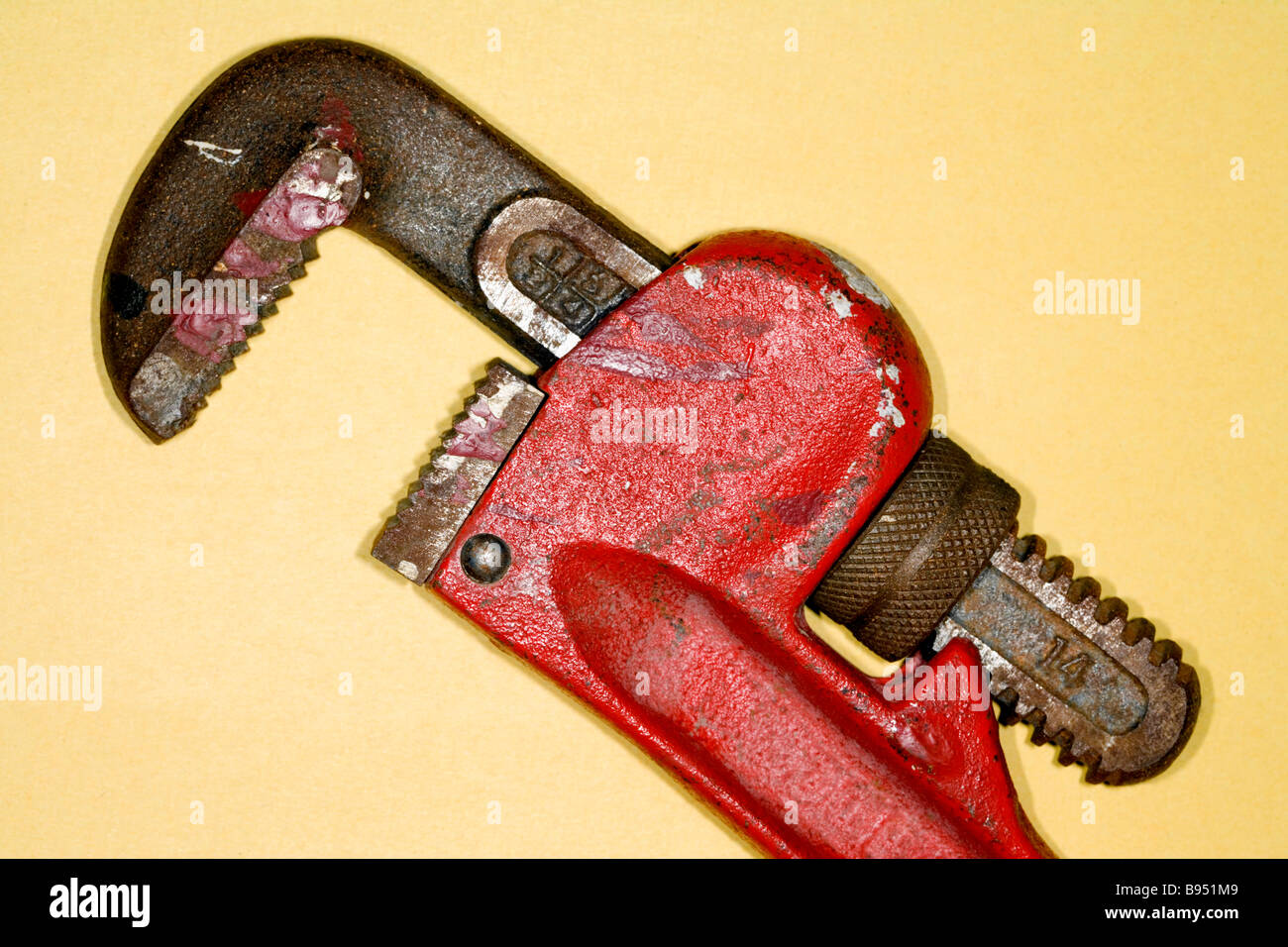 A pipe wrench on a yellow background Stock Photo - Alamy
