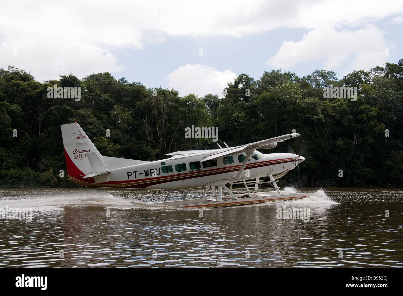 A Caravan float plane takes off from a small blackwater tributary that ...