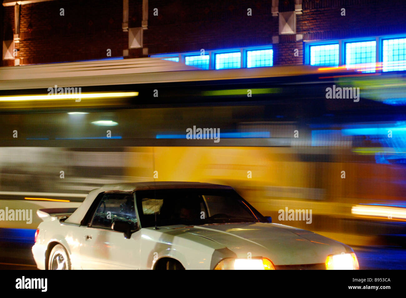 Automobile in heavy night time city traffic with a public bus zooming ...