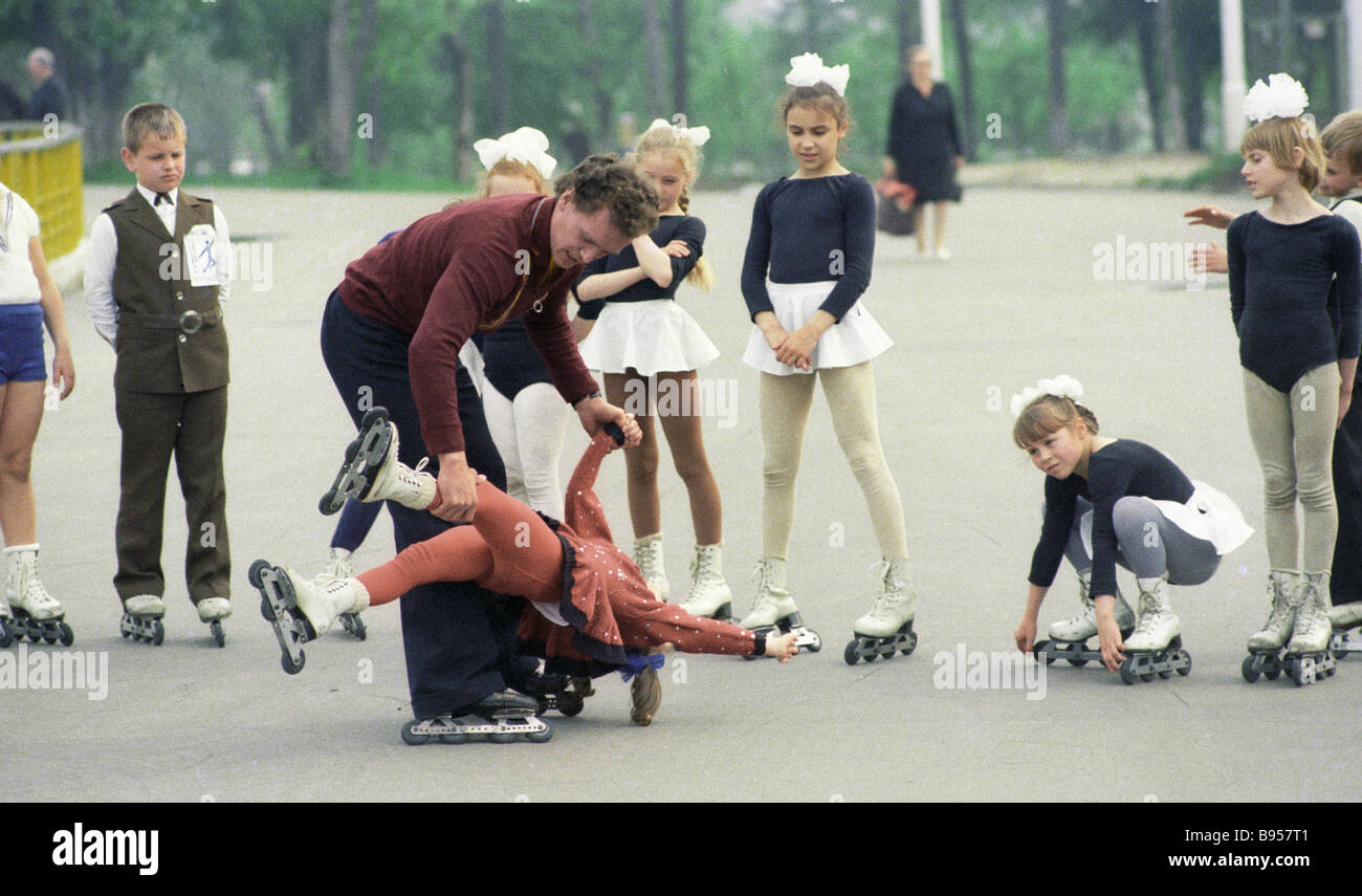 Young figure skaters training on roller skates with their coach on the ...