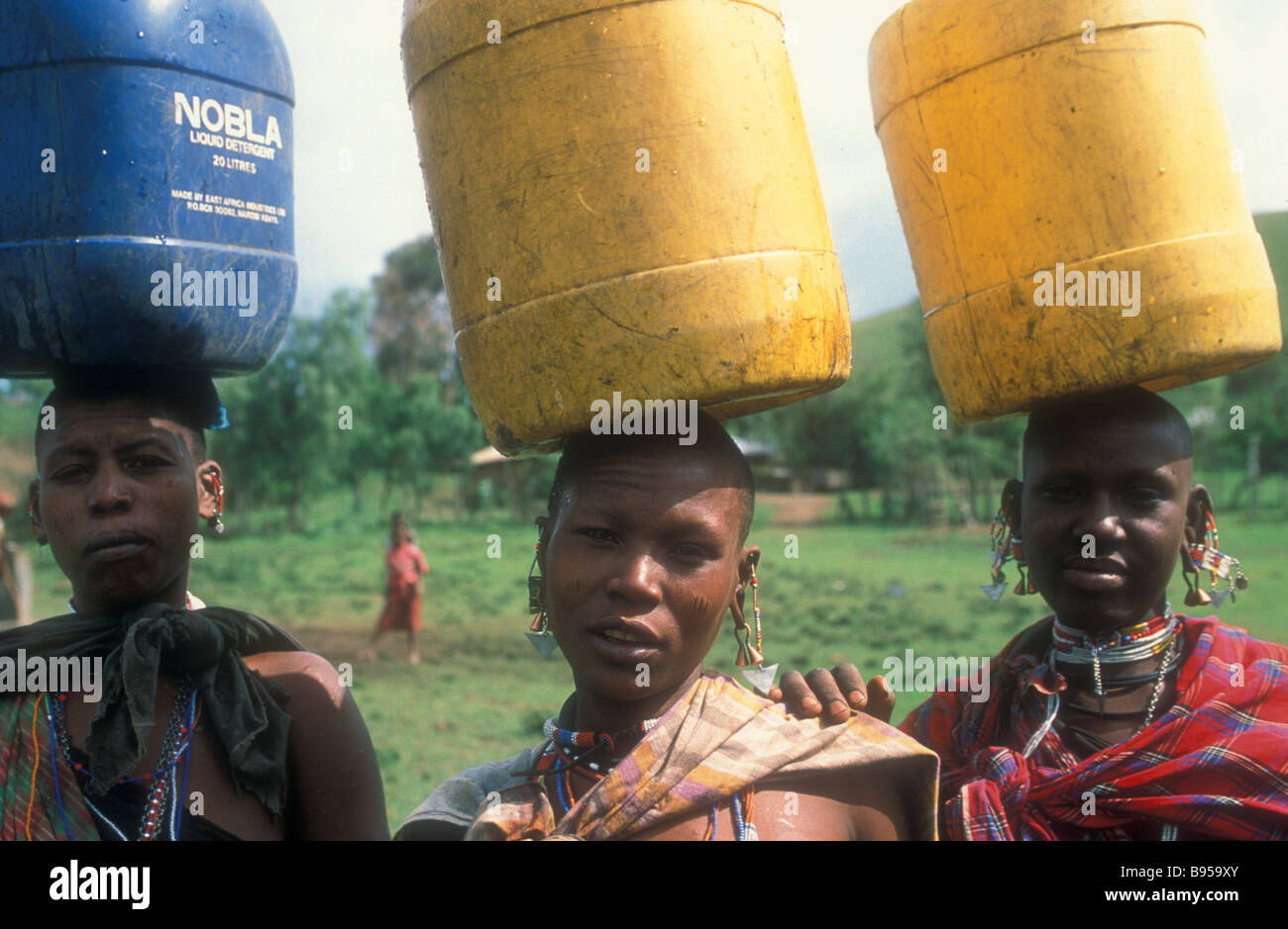 Tanzania. Maasai women carrying barrels with water Stock Photo - Alamy