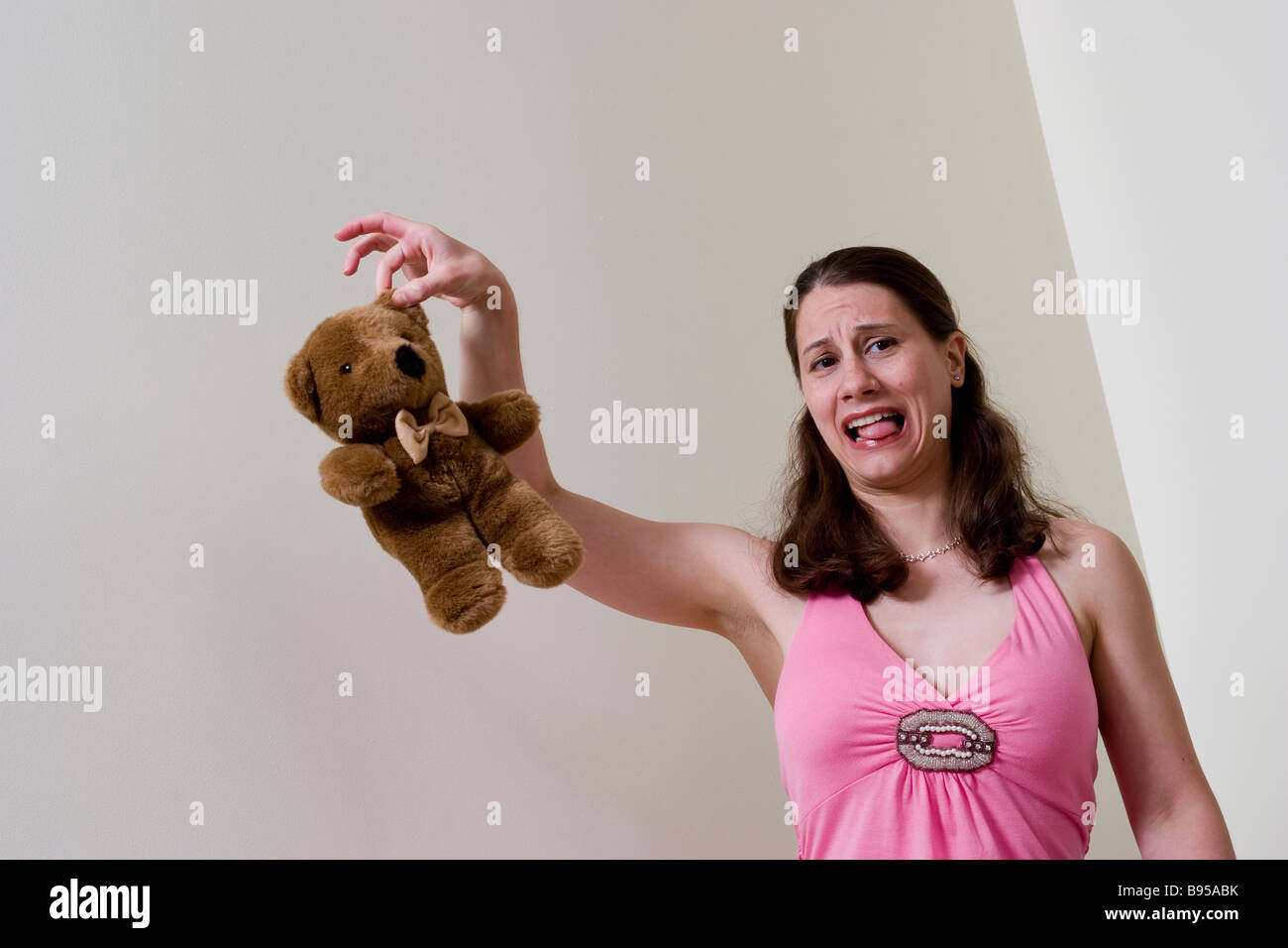 Young woman holding a stuffed animal by its ear MODEL RELEASED Stock ...