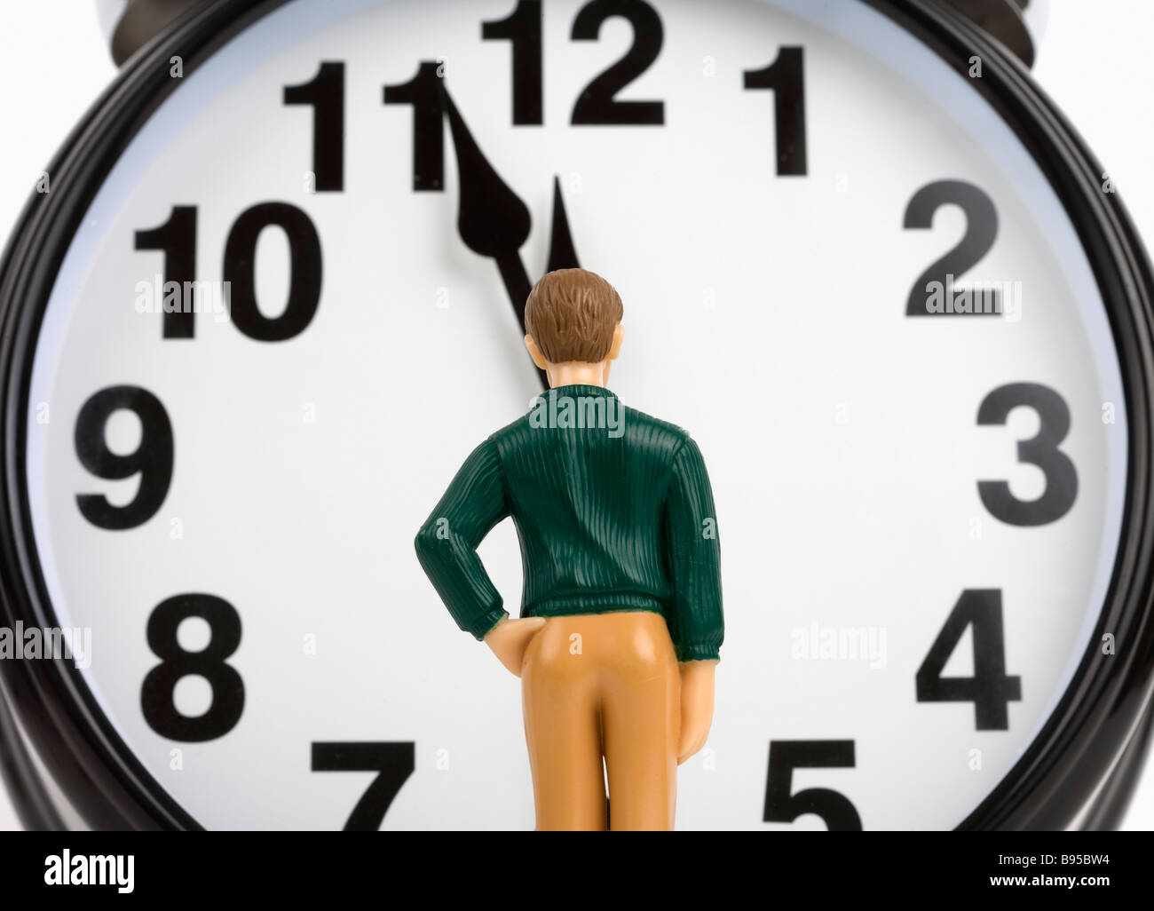 A man figurine stares at a clock Stock Photo - Alamy