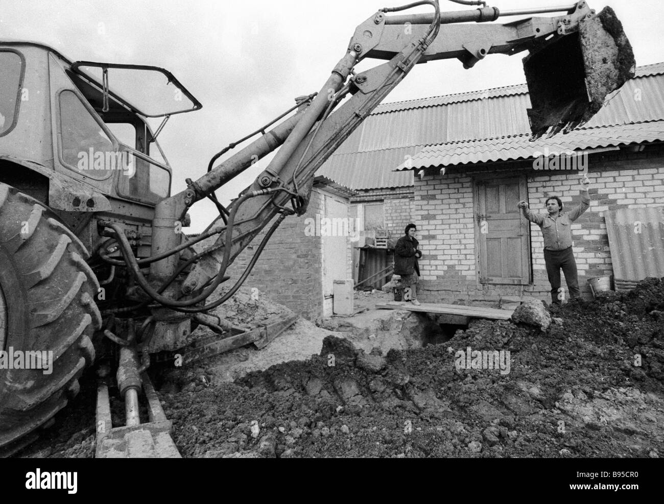 An excavator digging a foundation pit for a new farmhouse Stock Photo ...