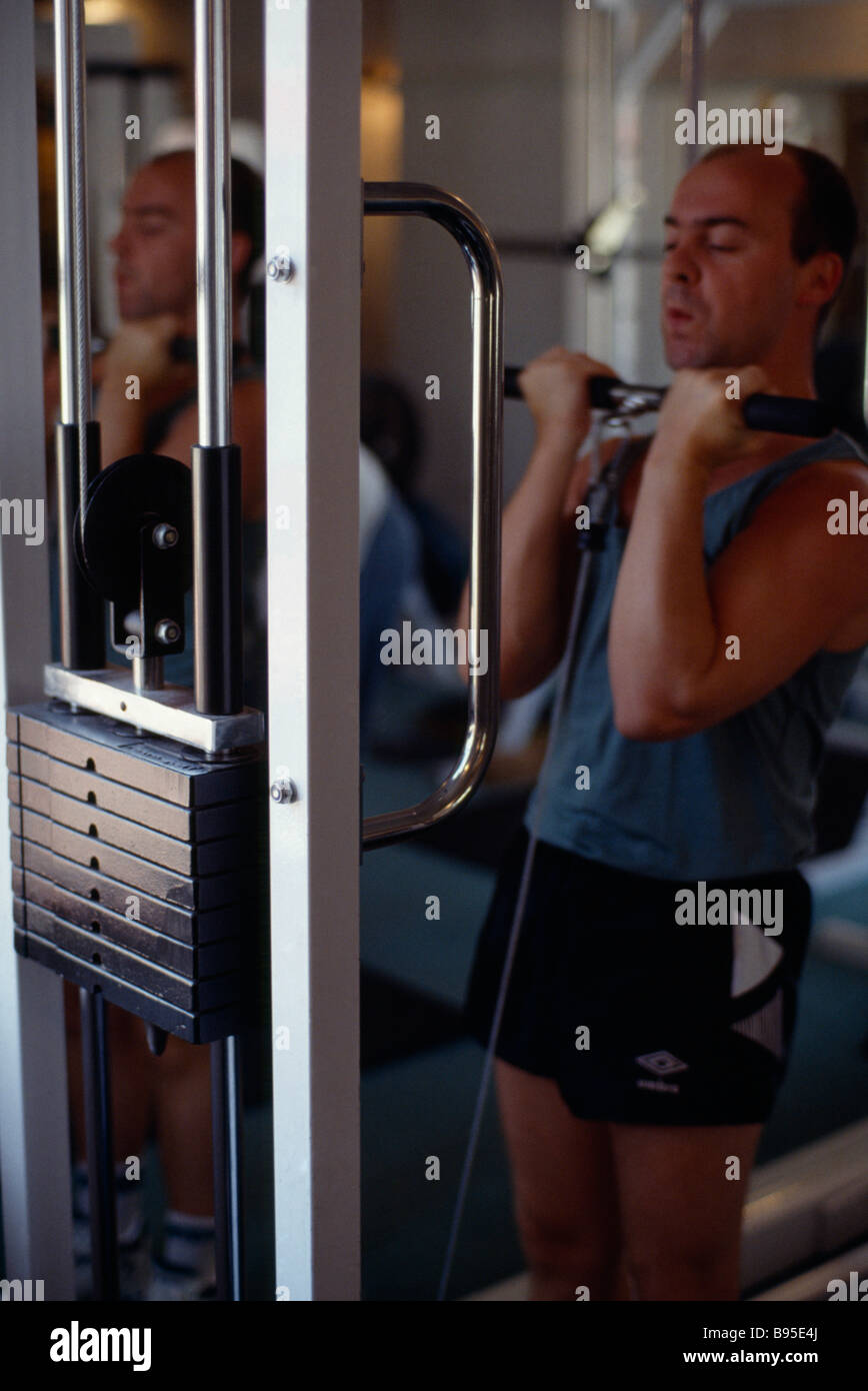 SPORT Fitness Gym Man working on biceps on weight machine Stock Photo ...
