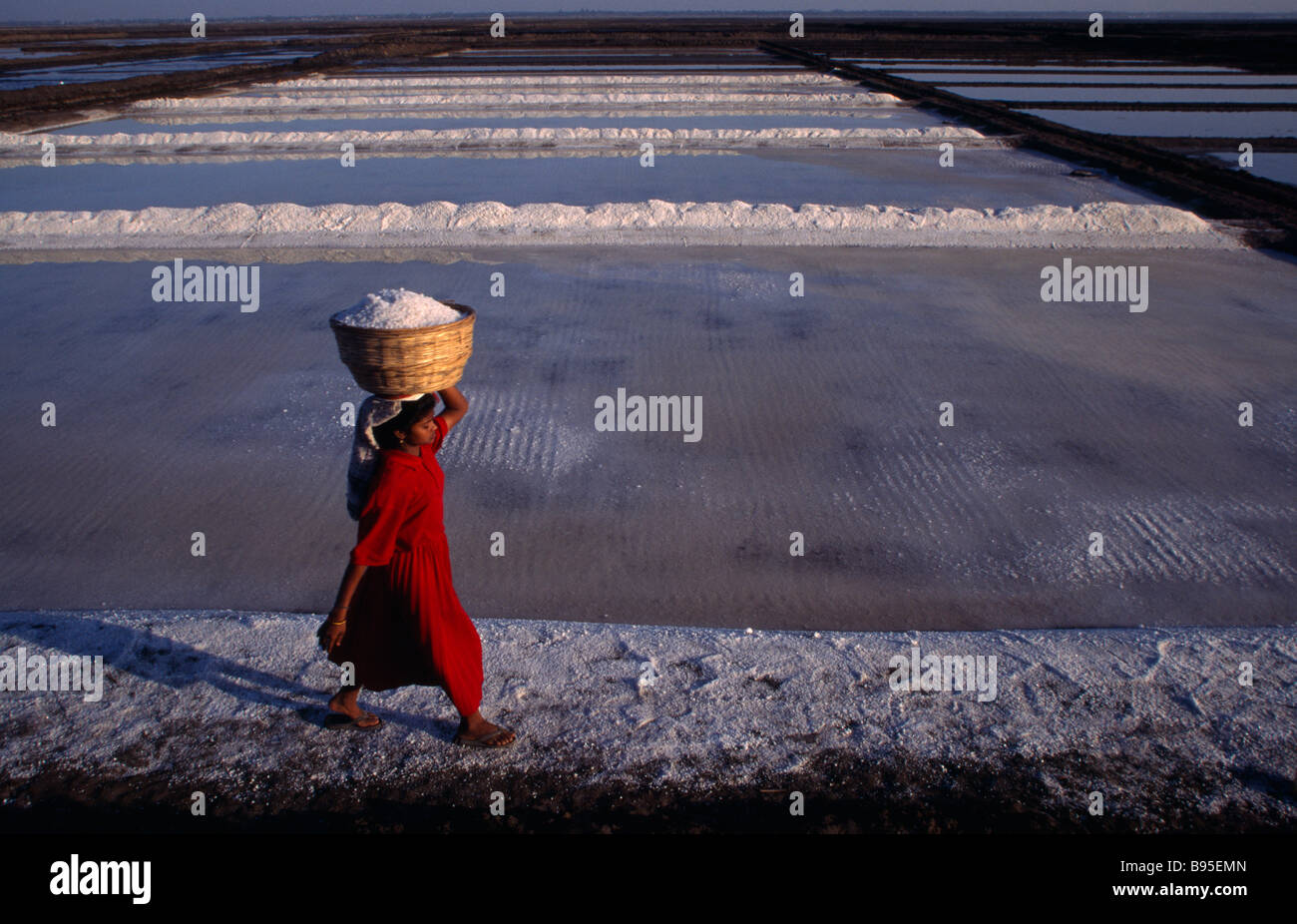 INDIA South Asia Gujarat Diu Woman wearing red sari carrying salt in ...