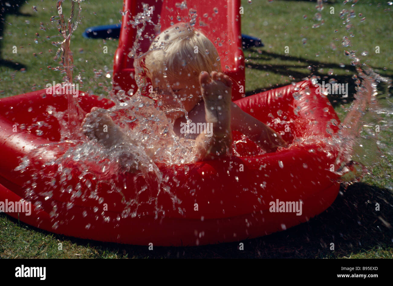 SPORT Water Paddling Pool Young boy splashing in a red inflatable ...