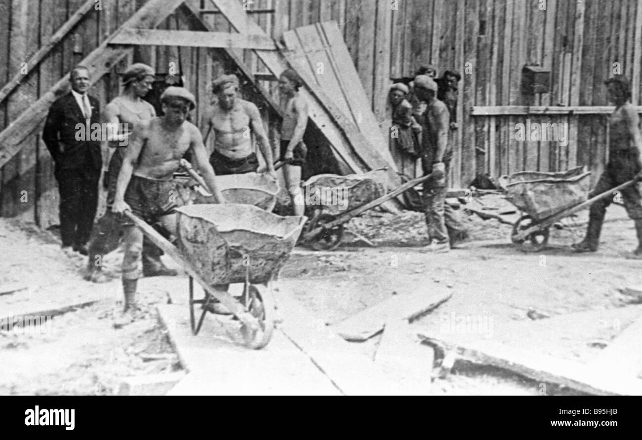 Workers push the carts with cement Stock Photo - Alamy
