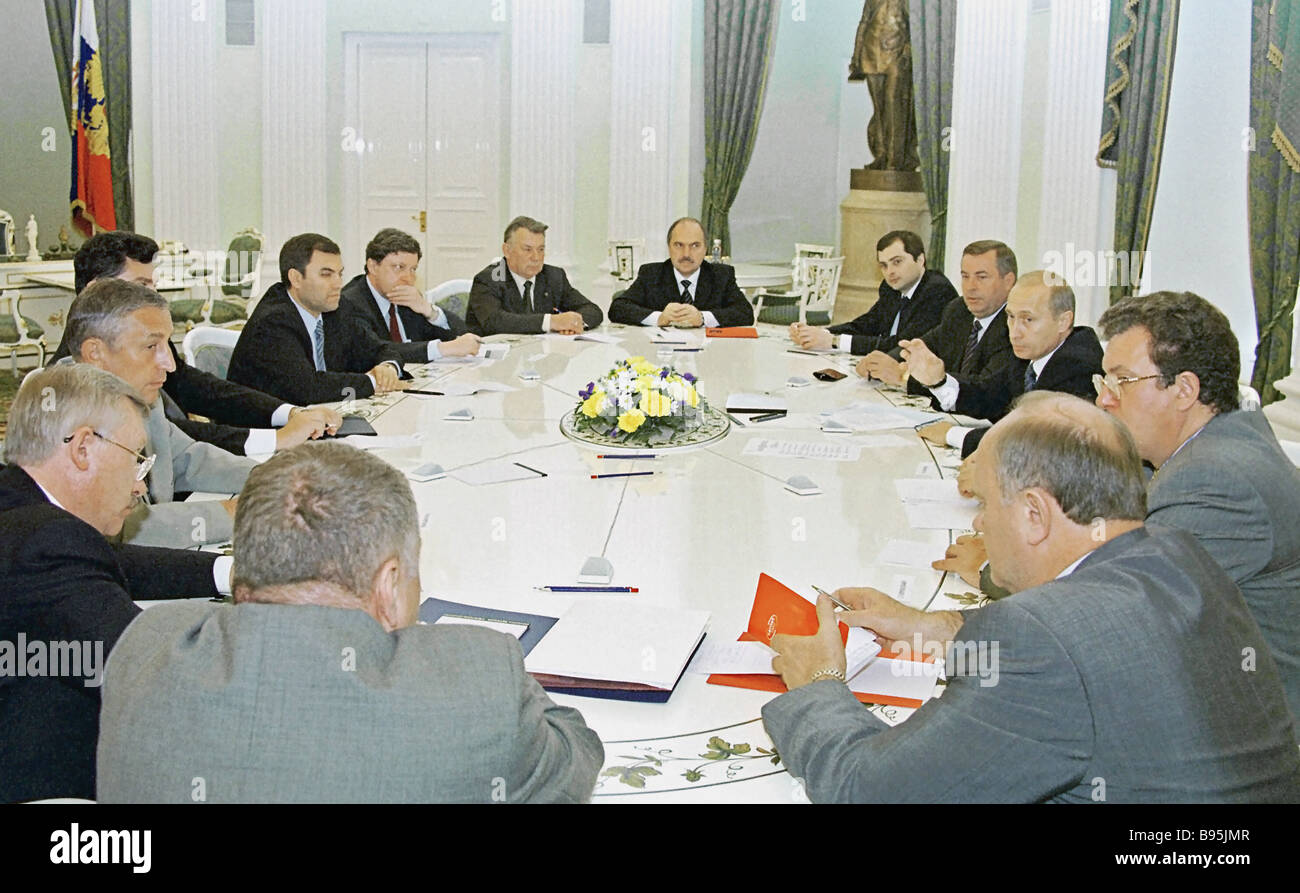 Russian President Vladimir Putin (right, with hand raised) meeting with ...