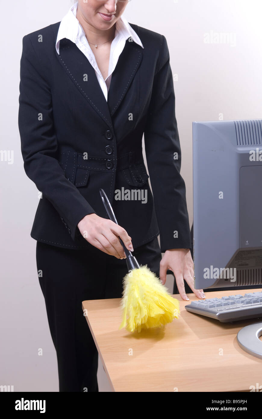 Business woman dusting desk Stock Photo - Alamy