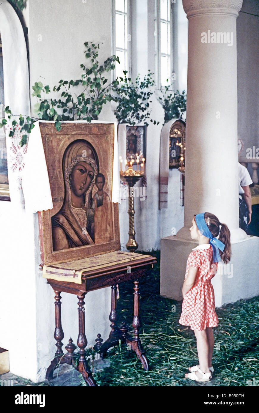 A girl standing in front of the icon of Our Lady in a church on the day ...