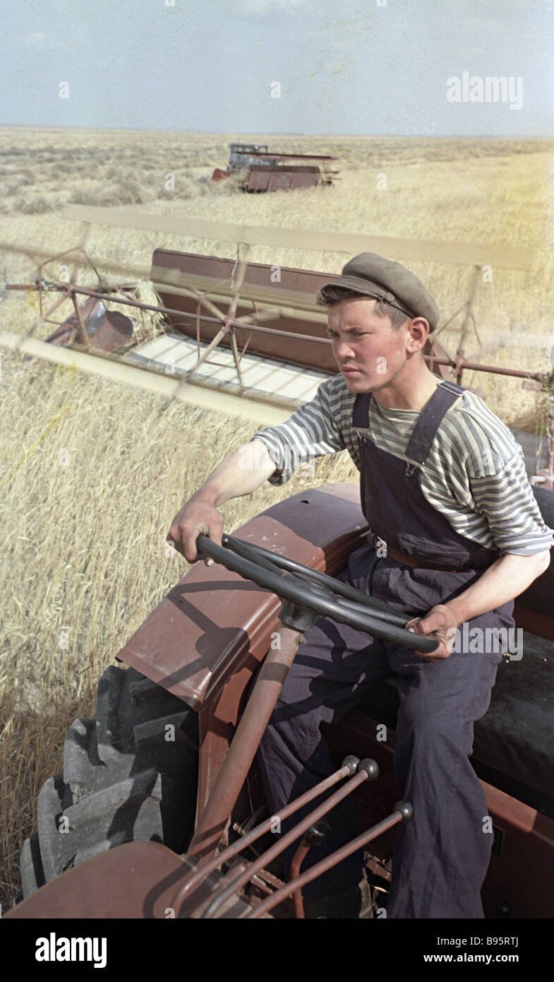 A tractor operator of a collective farm at the mowing line Stock Photo ...