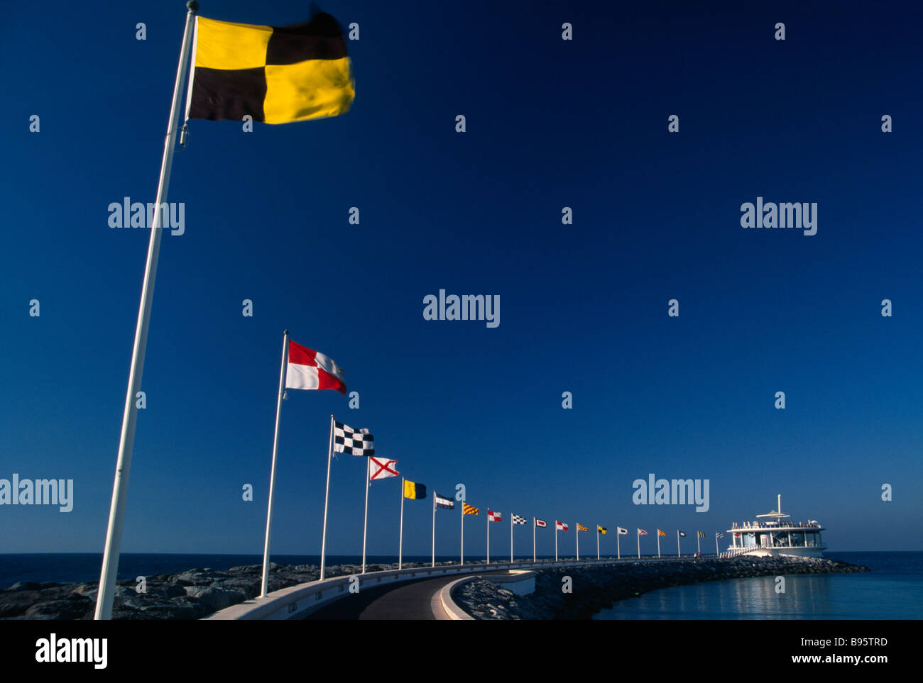 UAE Dubai Jumeirah Beach. Curving marina wall and line of flags Stock ...