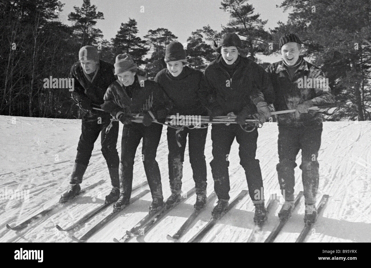 Skiers sliding downhill in a team Stock Photo - Alamy