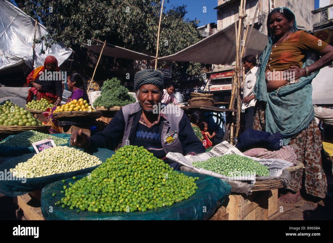 INDIA Gujarat Ahmedabad Vegetable market vendor selling fresh beans and ...
