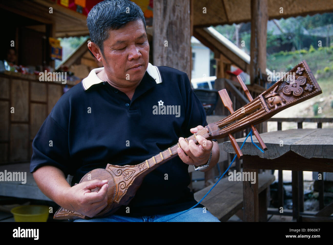THAILAND North Chiang Mai Hills Man playing traditional four stringed ...