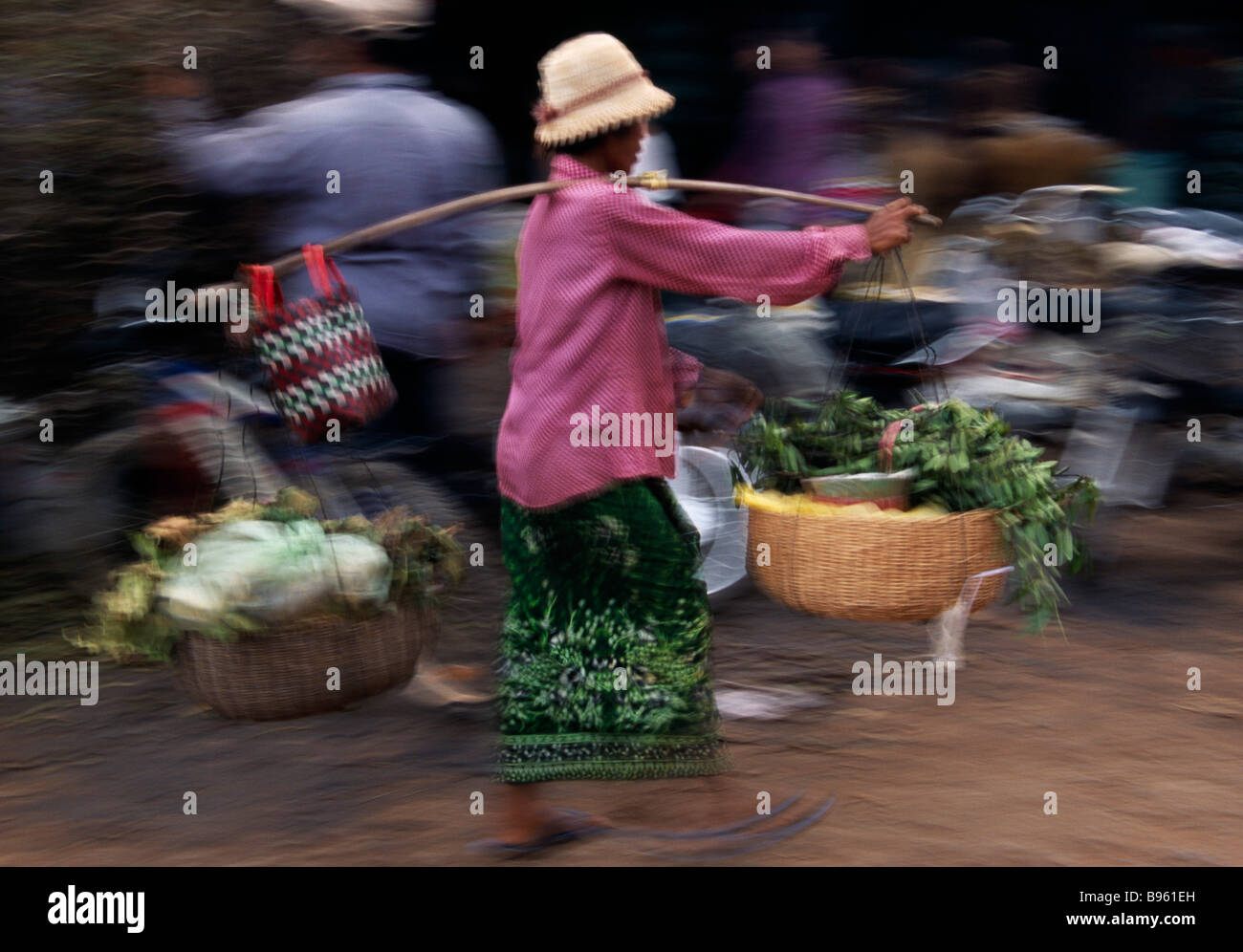 CAMBODIA Siem Reap Blurred action of moving woman carrying fresh ...