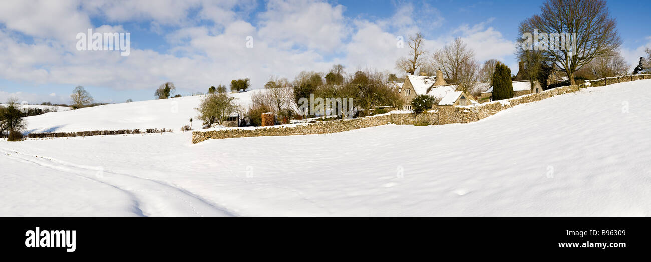 A panoramic view of a cottage in winter snow in the Cotswold village of ...