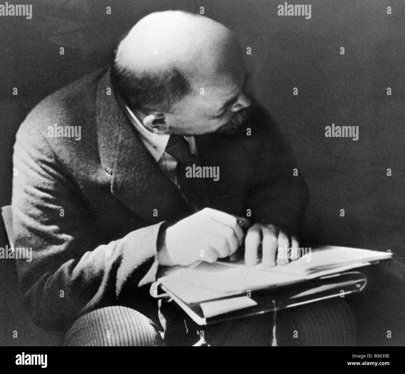Vladimir Lenin on the rostrum steps is making notes during the meeting ...