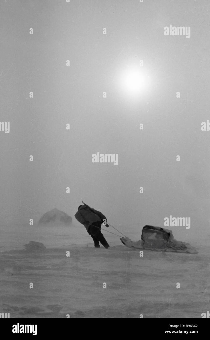A hunter drawing ice coated sledge to a halting place Stock Photo - Alamy