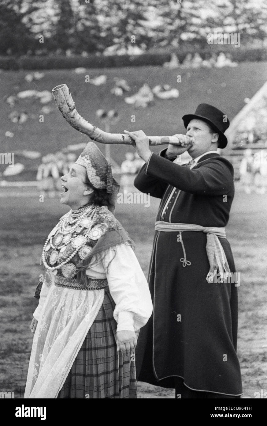 An Estonian in national costume singing a national song accompanied by ...