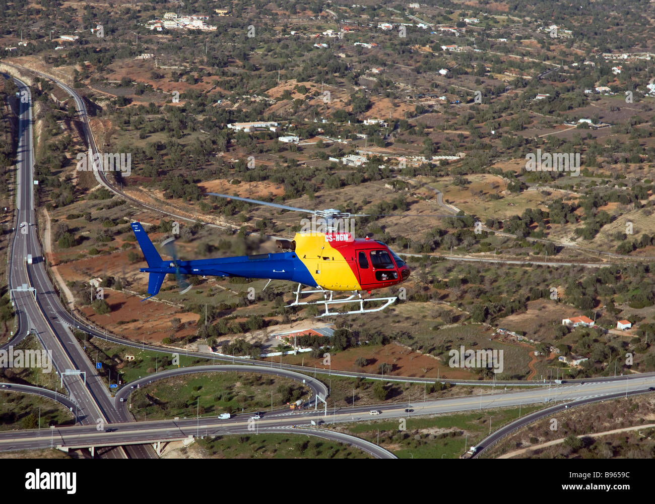 A multipurpose helicopter in colourful livery flies over the A22 ...
