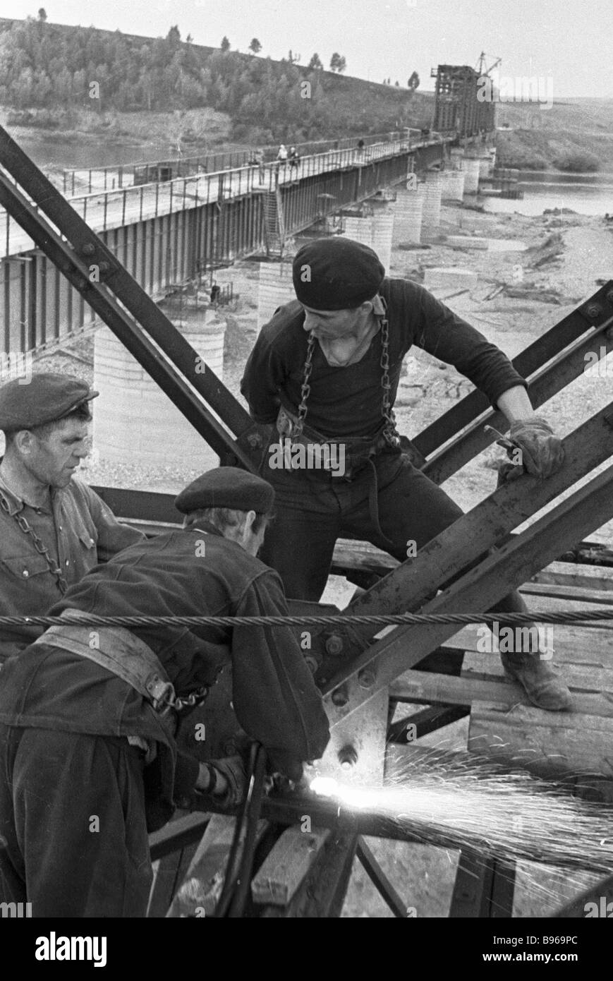 A team of riggers completing a bridge over the Tom River Stock Photo ...