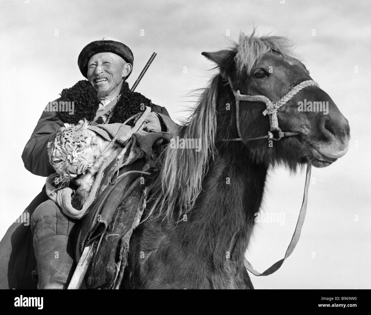Hunter with a caught snow leopard Stock Photo - Alamy
