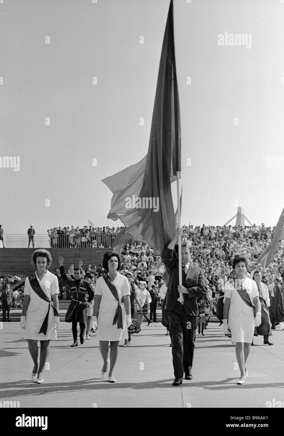 Representatives of the Soviet pavilion carry state Soviet flag on the ...