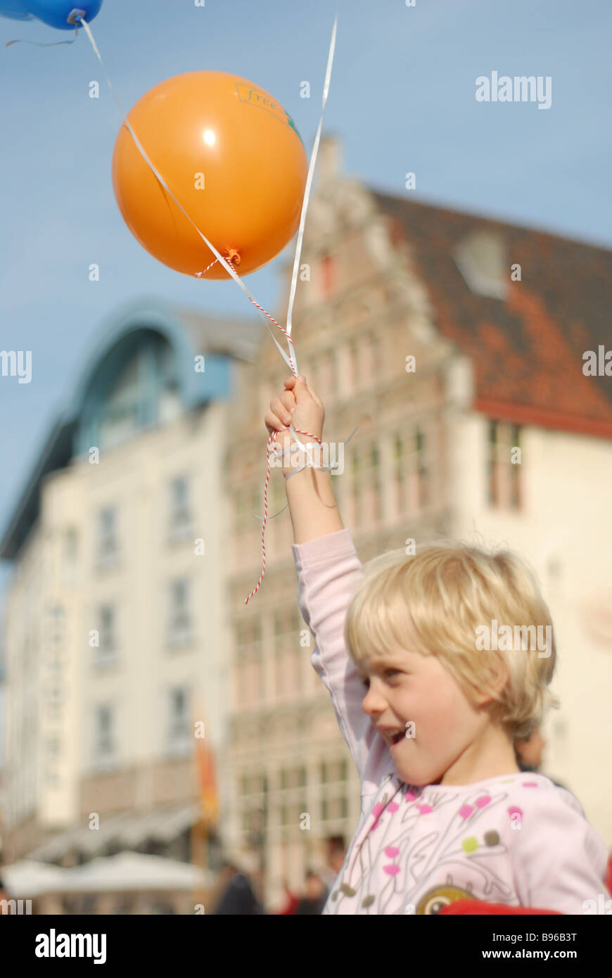 a happy kid holding on to balloons Stock Photo - Alamy