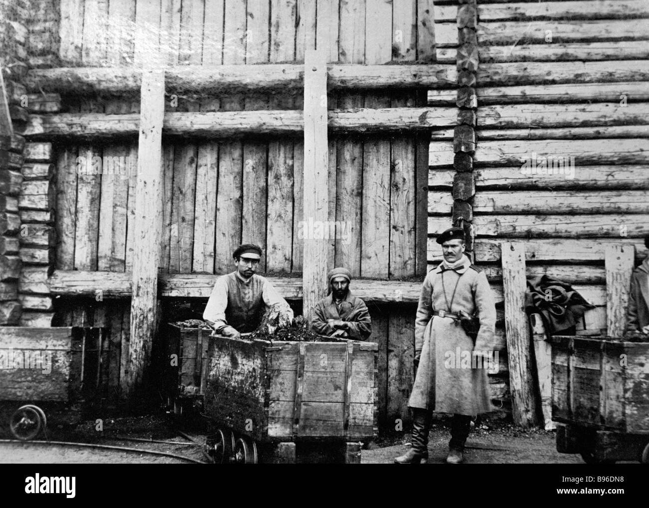 A reproduction of a photograph of miners rolling off a car full of coal ...