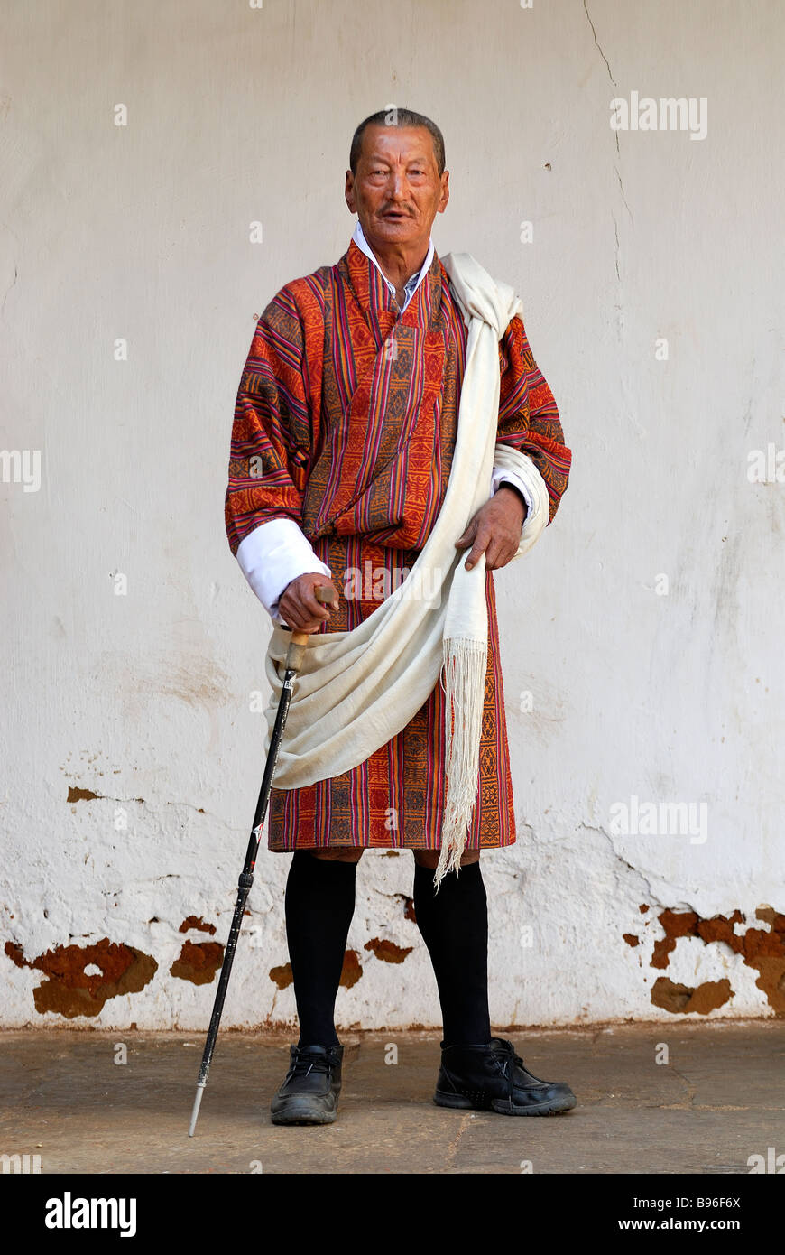 Bhutan, Punakha, old man in traditional dress watching the Tsechu ...