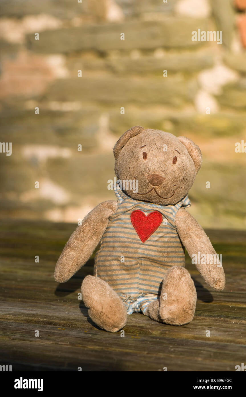 Grubby abandoned teddy bear on a wooden table Stock Photo - Alamy