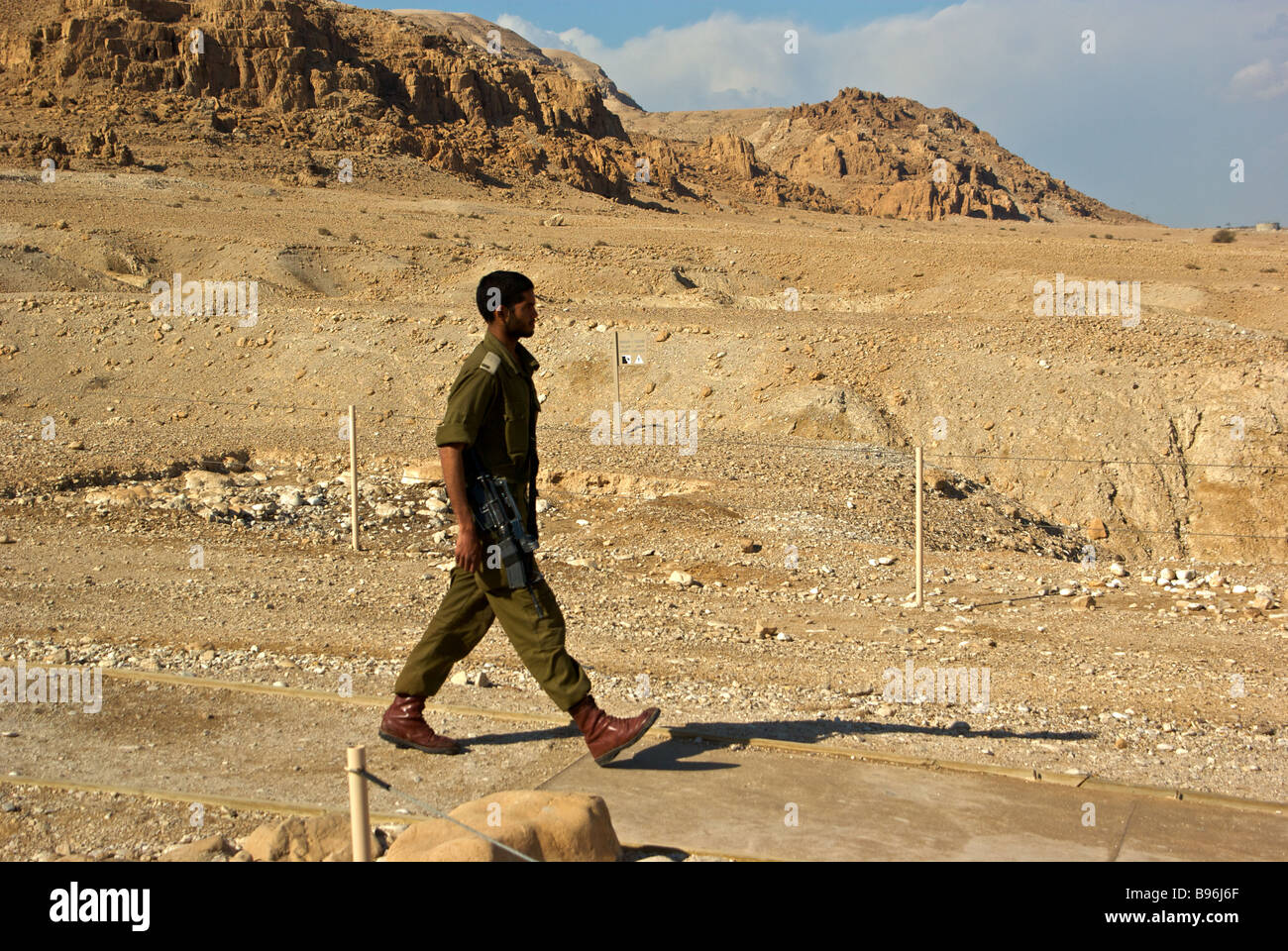 Armed young Israeli soldier on guard duty patrol at Qumran National ...