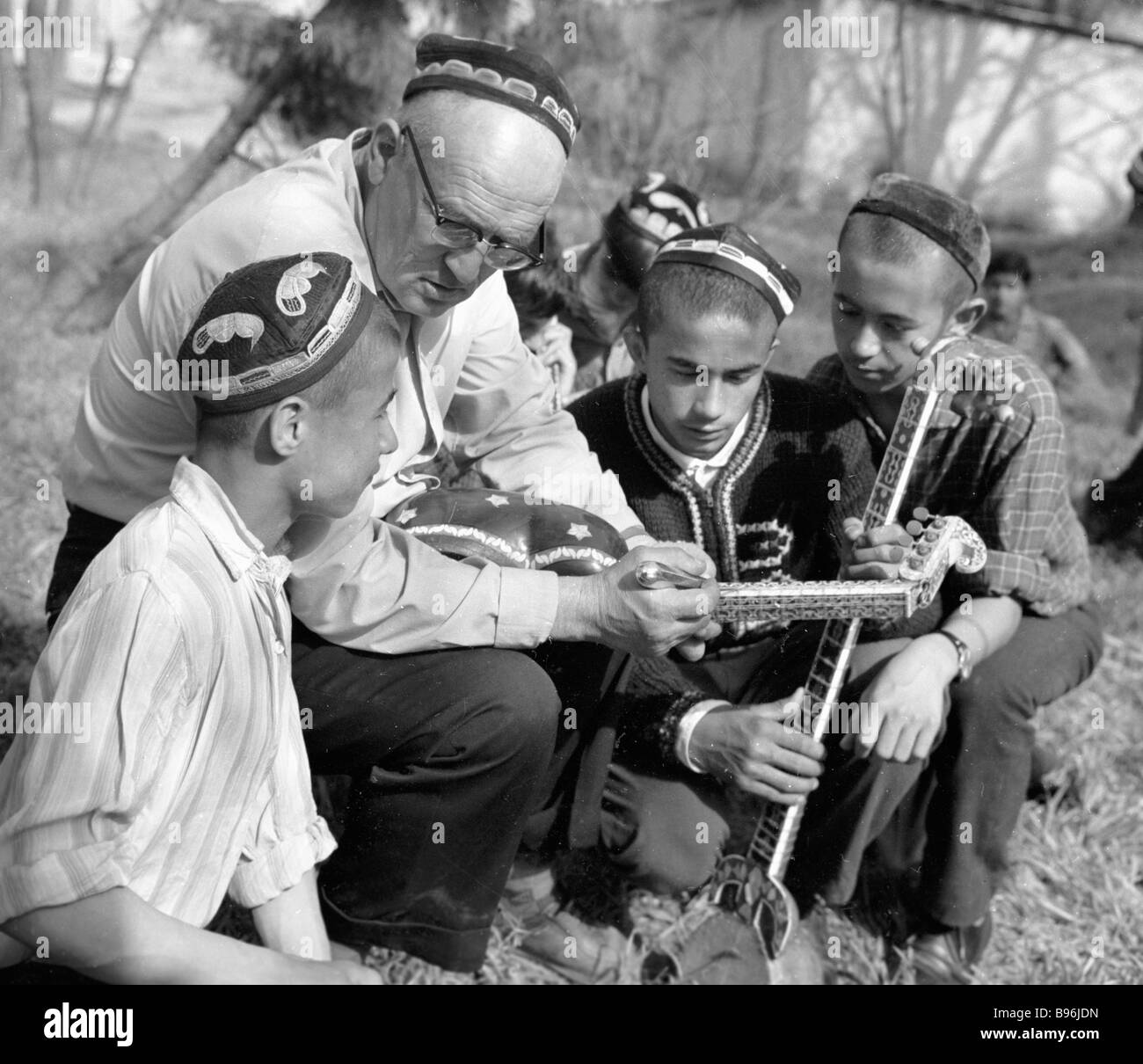 An old musician teaches children playing folk instruments Stock Photo ...