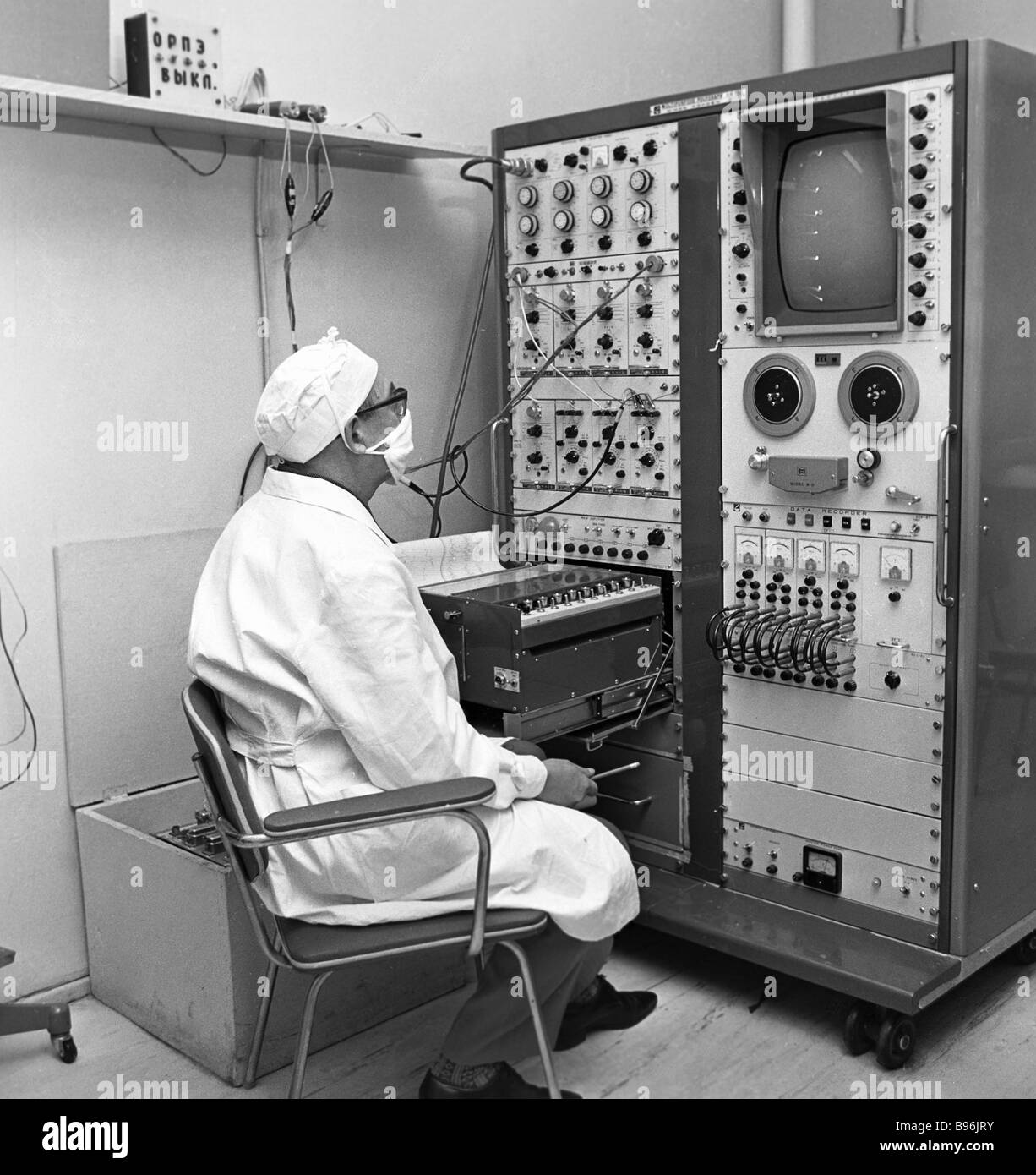 A physiologist monitors the electrical brain activity readings during ...