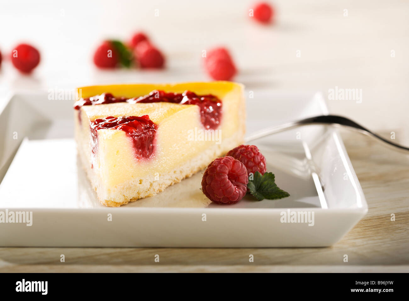 one piece of raspberry cheesecake on square plate Stock Photo - Alamy