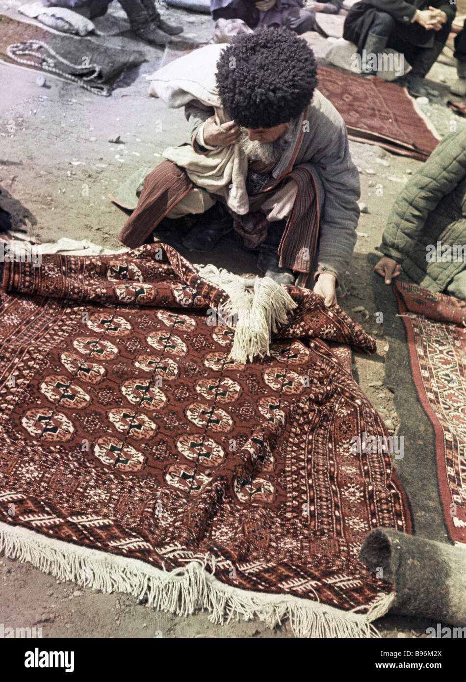 A man selling his carpet at a Turkmen bazaar Stock Photo - Alamy