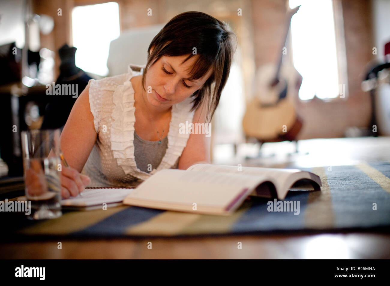 Young woman studying in urban loft Stock Photo - Alamy